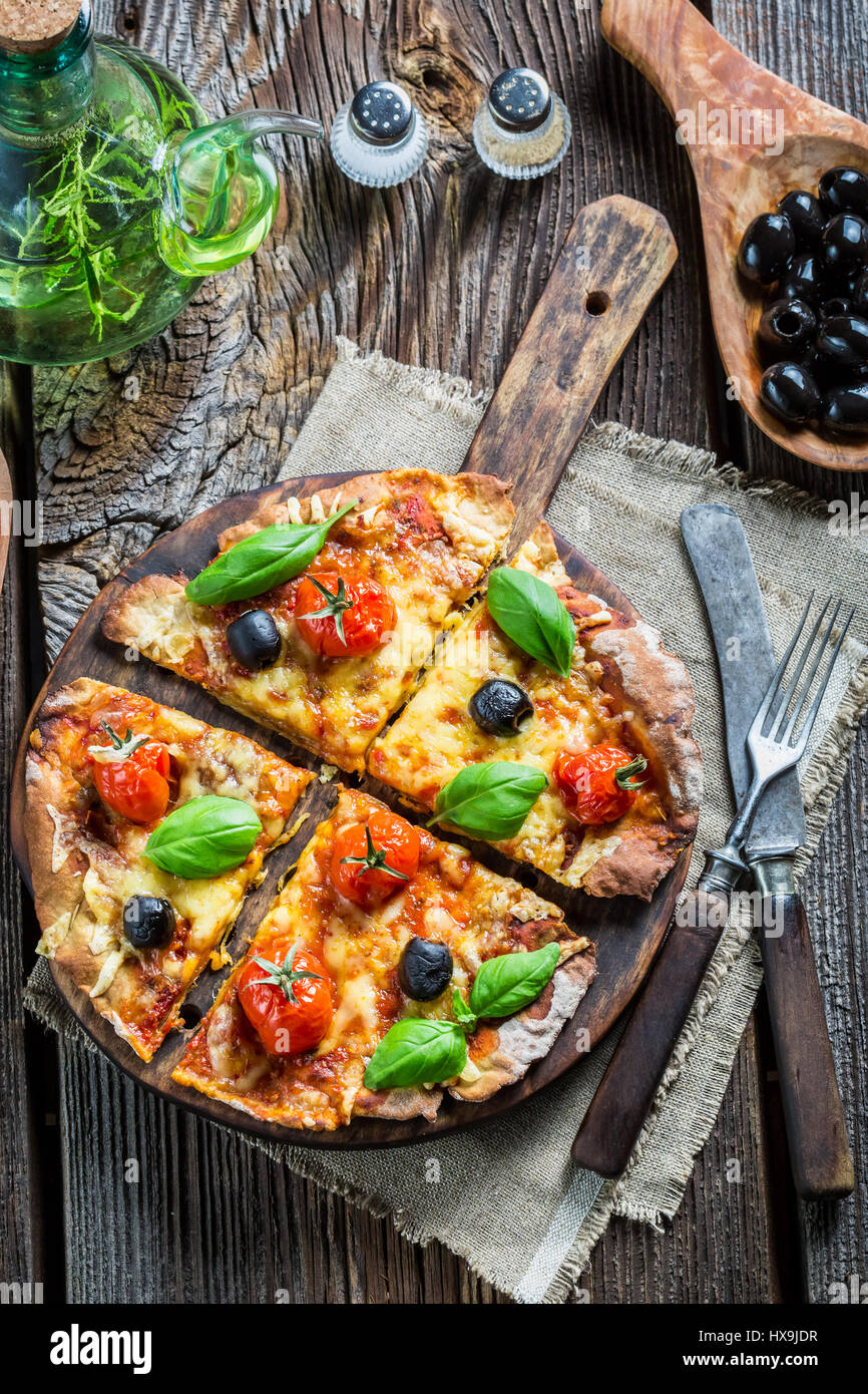 Prepared pizza before baking on old wooden table Stock Photo - Alamy