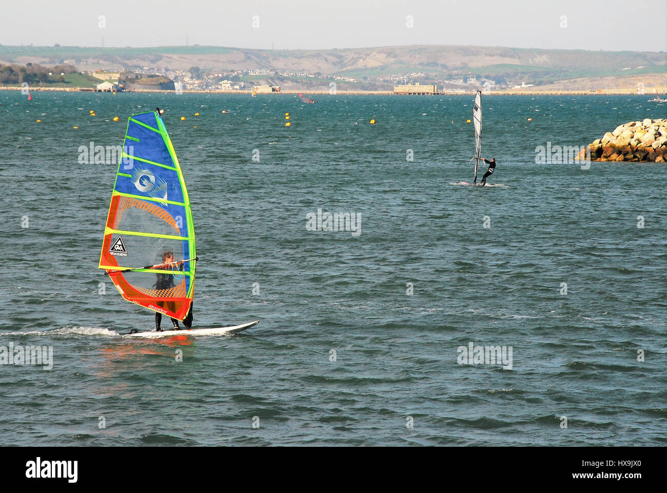 Portland, UK. 25th Mar, 2017. Windsurfers race across Portland harbour ...