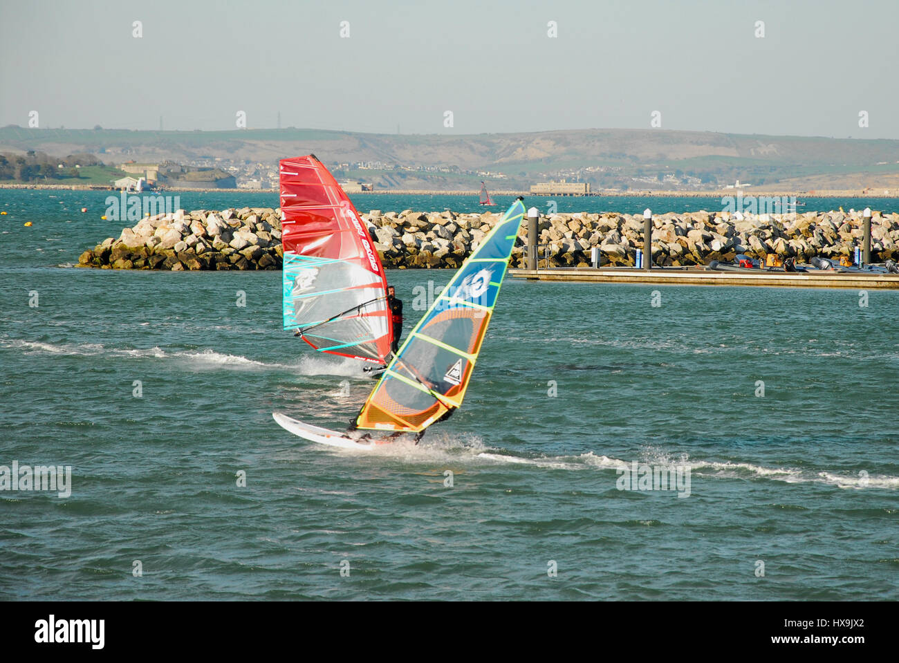 Portland, UK. 25th Mar, 2017. Windsurfers race across Portland harbour ...