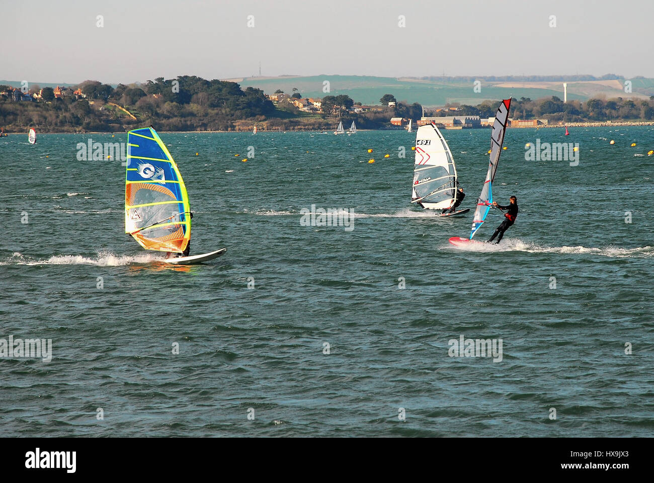 Portland, UK. 25th Mar, 2017. Windsurfers race across Portland harbour ...