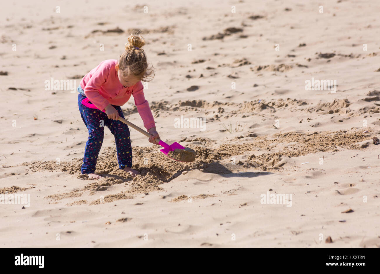 Girl with spade digging in the sand hi-res stock photography and images ...