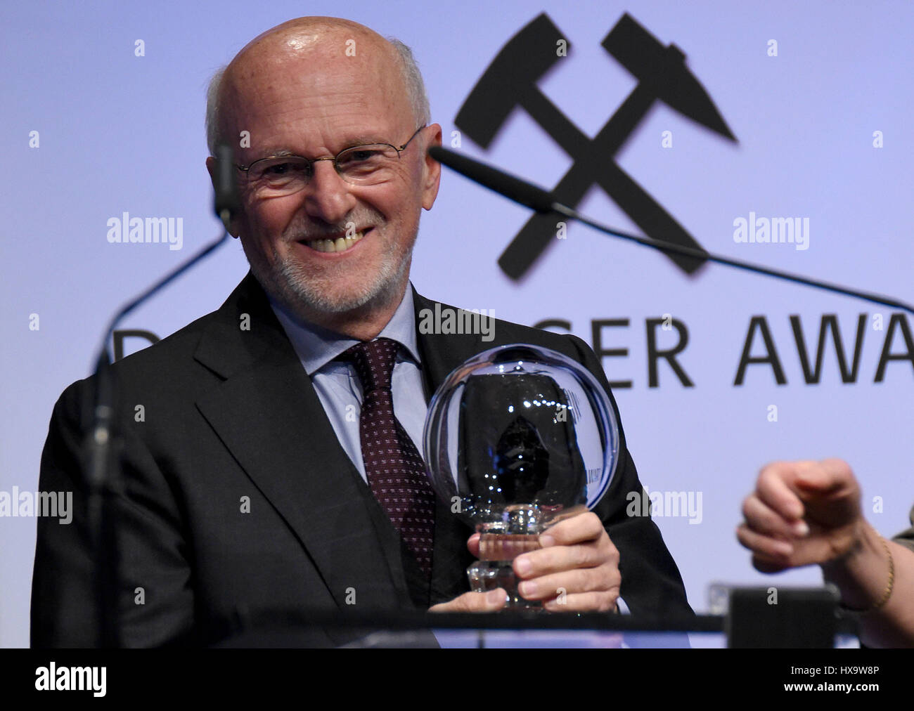 Businessman Dirk Rossmann standing on stage holding the award of the ...