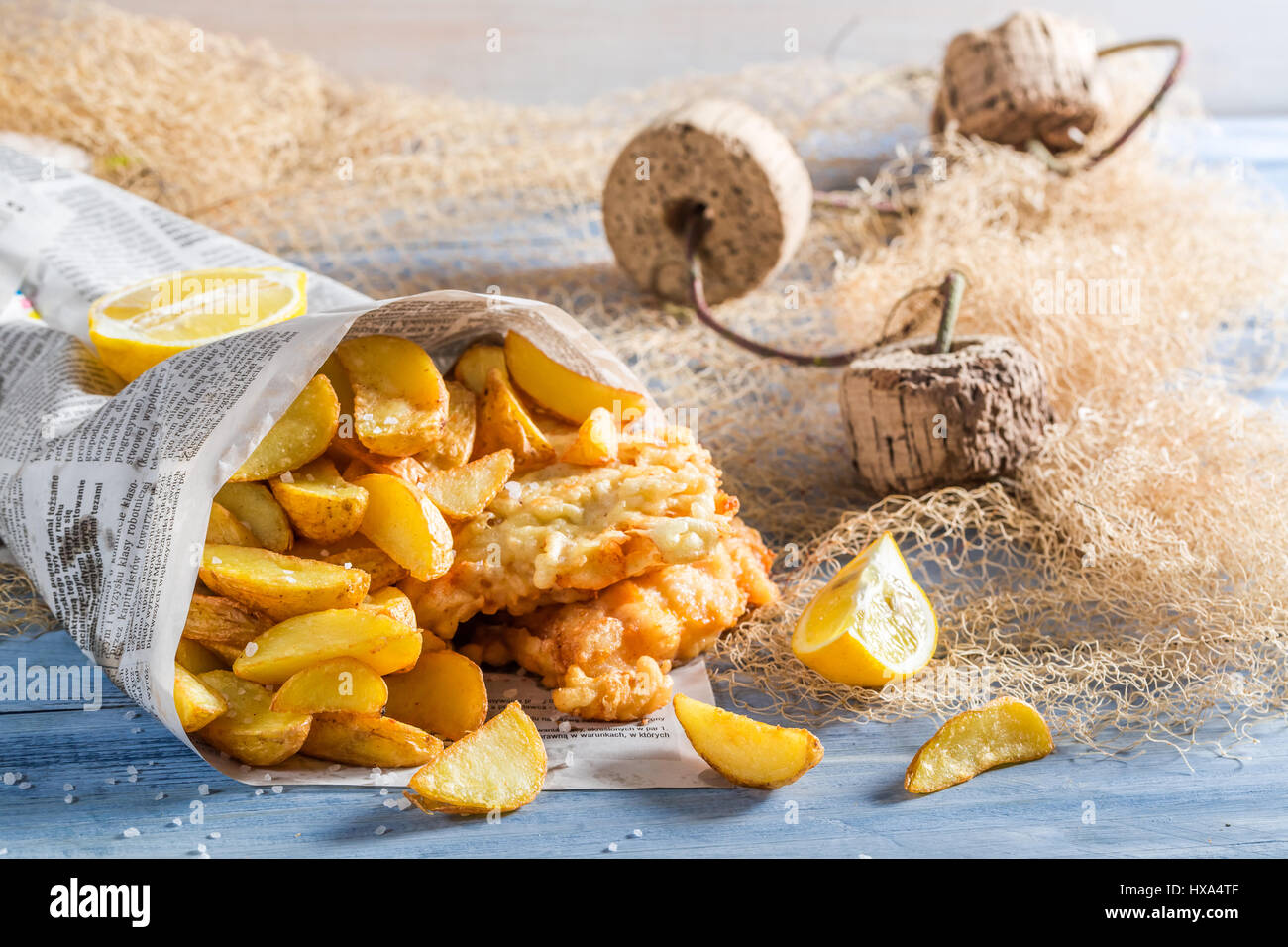 Hot fish and chips with lemon on old wooden table Stock Photo - Alamy