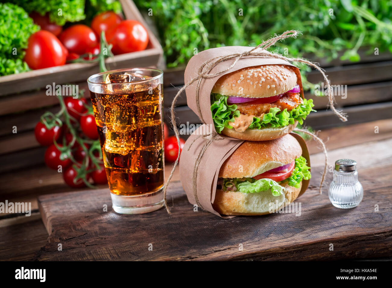 Takeaway tasty burger with cold drink on old wooden table Stock Photo ...