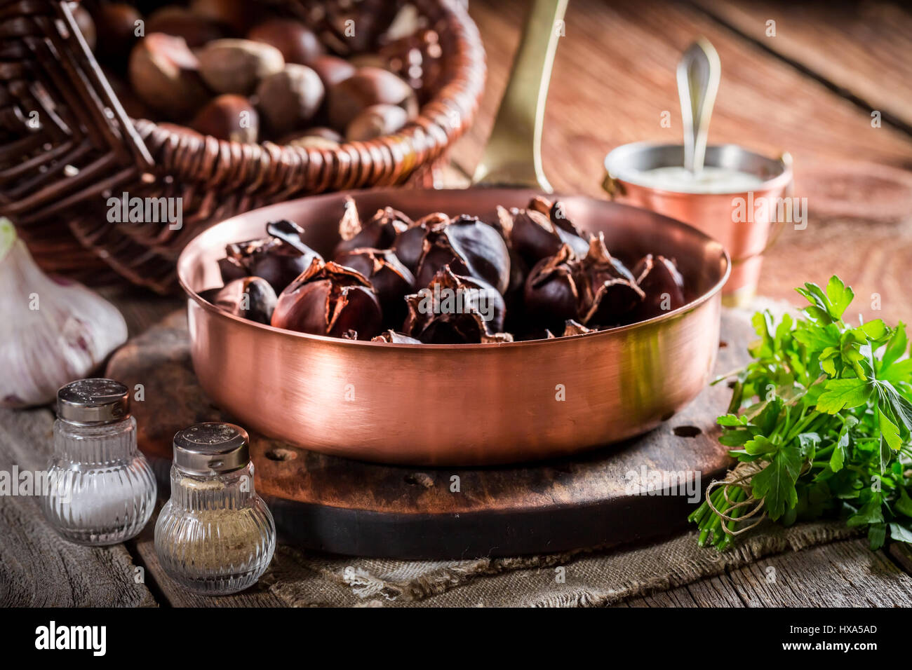 Fresh chestnuts with garlic sauce on old wooden table Stock Photo - Alamy