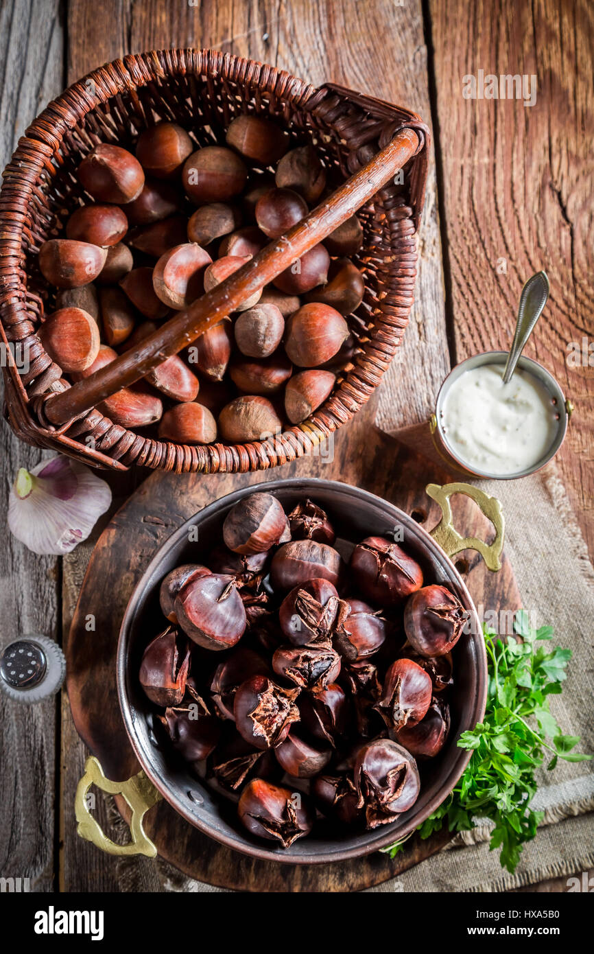 Closeup of delicious chestnuts with parsley on old wooden table Stock ...