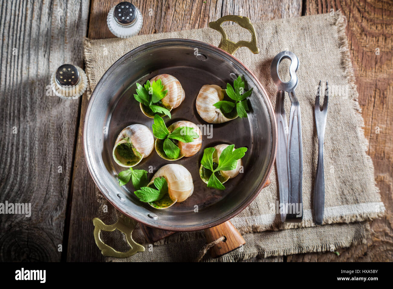 Roasted snails with garlic butter on old wooden table Stock Photo - Alamy