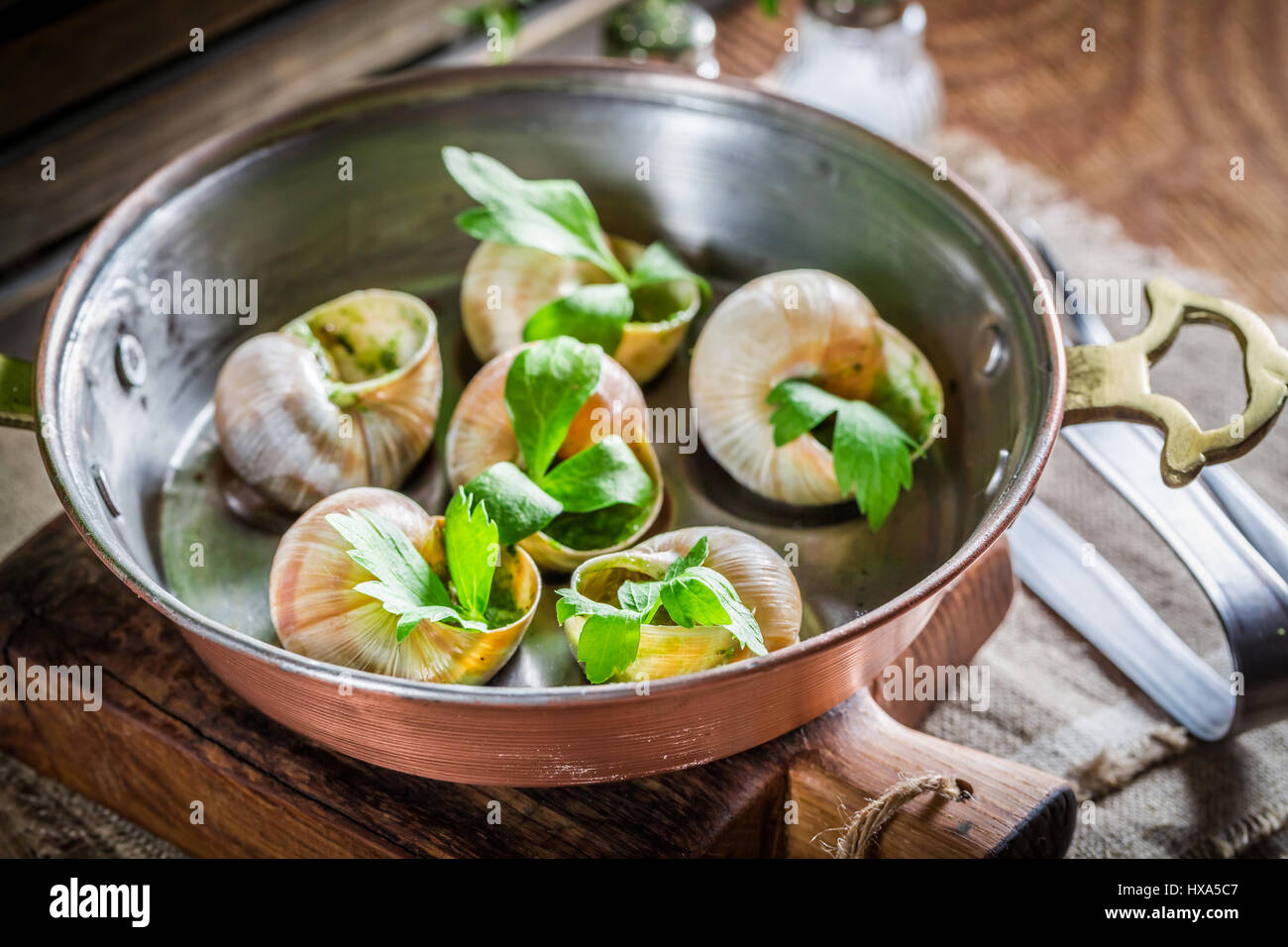 Cooking snails with parsley and garlic butter Stock Photo - Alamy