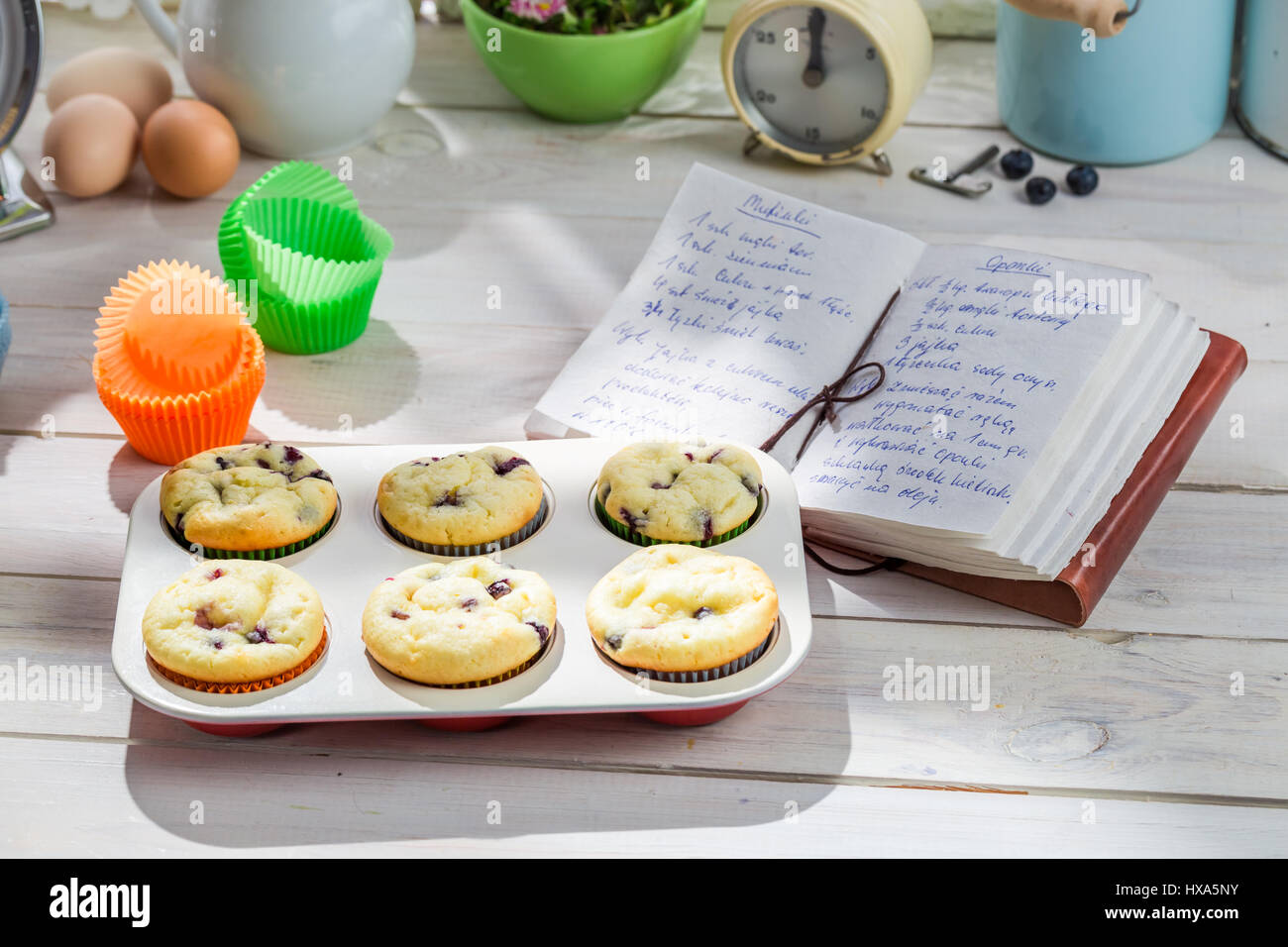 Decorating tasty muffins with sweet cream on old white table Stock ...
