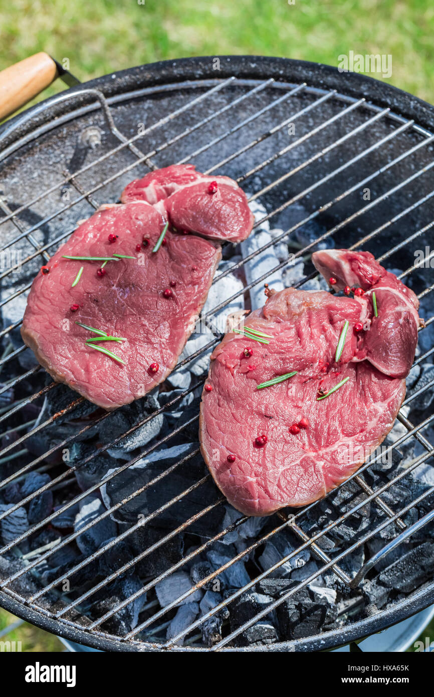 Roasting red meat with rosemary on grill Stock Photo - Alamy
