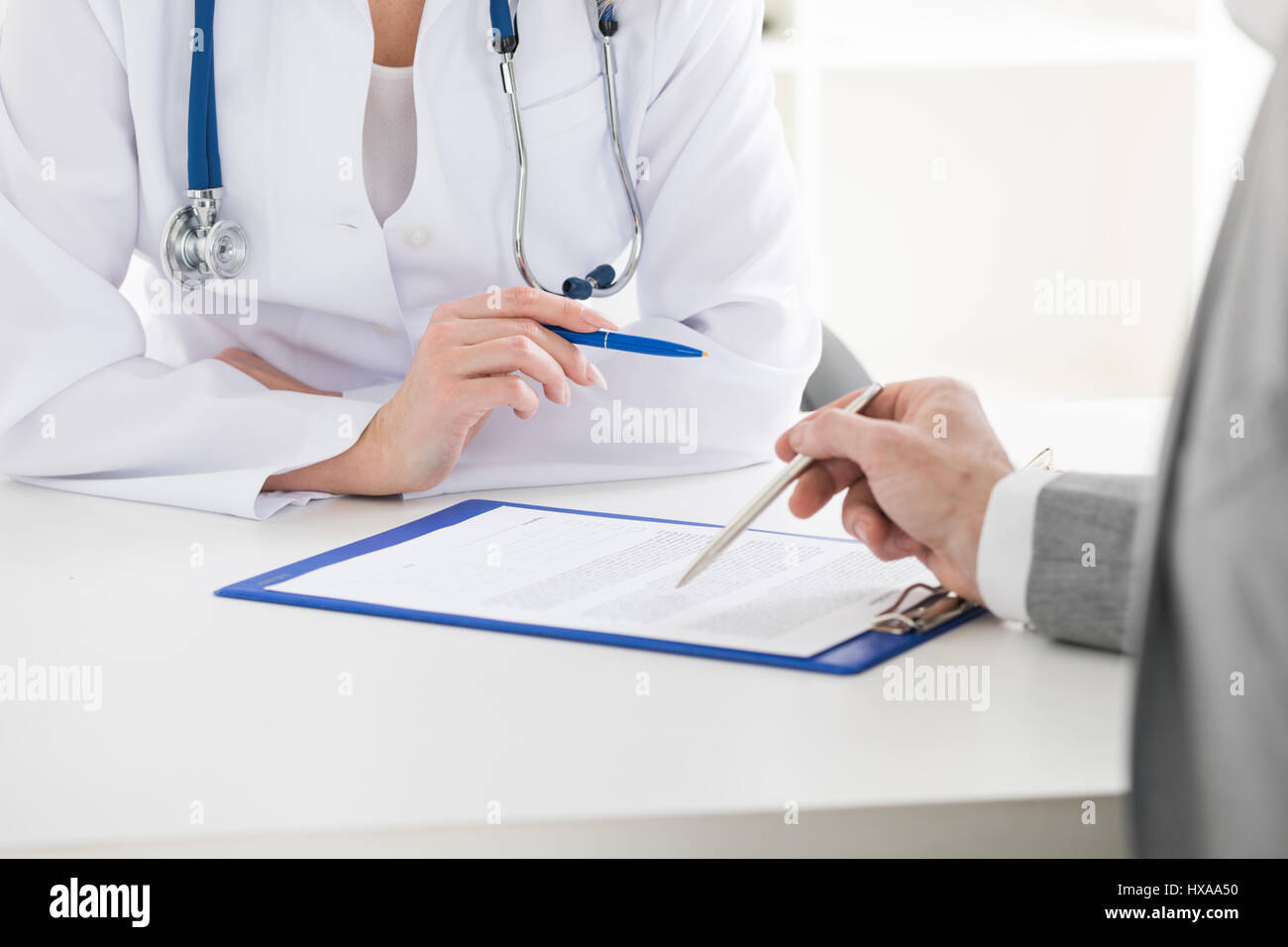 Female doctor holding consulting patient showing documents Stock Photo ...