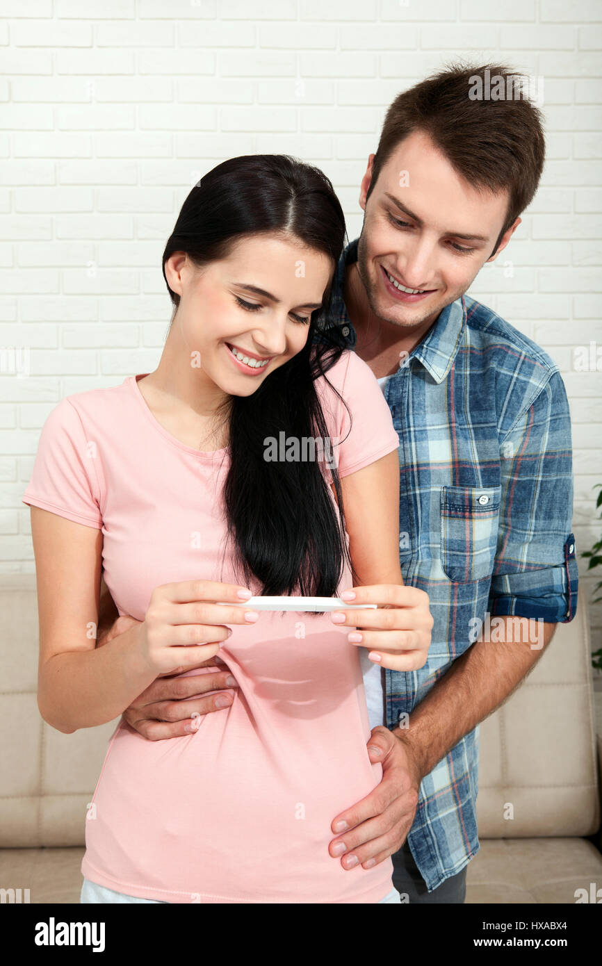 Happy excited couple making positive pregnancy test and celebrating ...