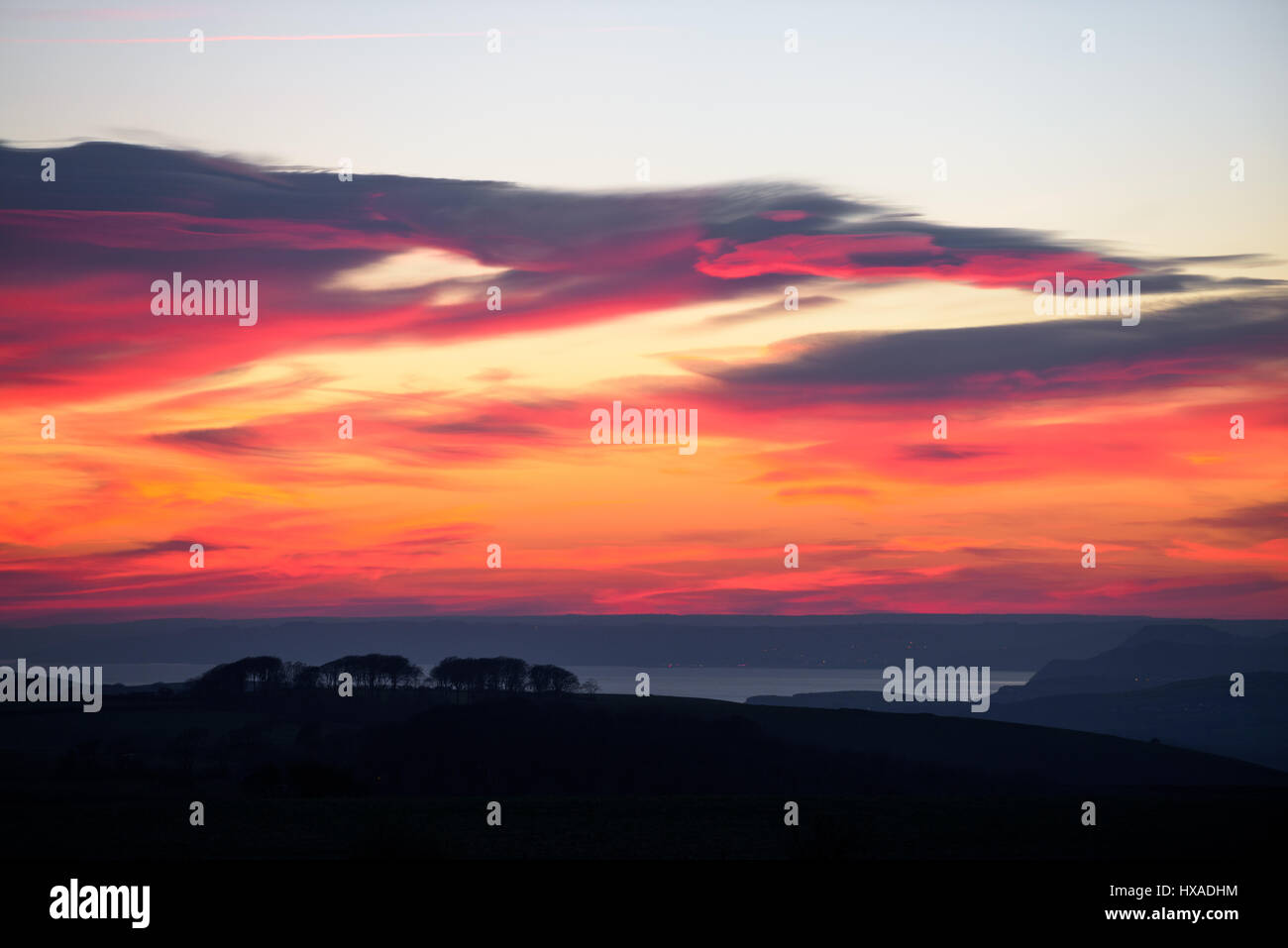 A fiery red sunset over west Dorset towards West Bay and Lyme Regis ...