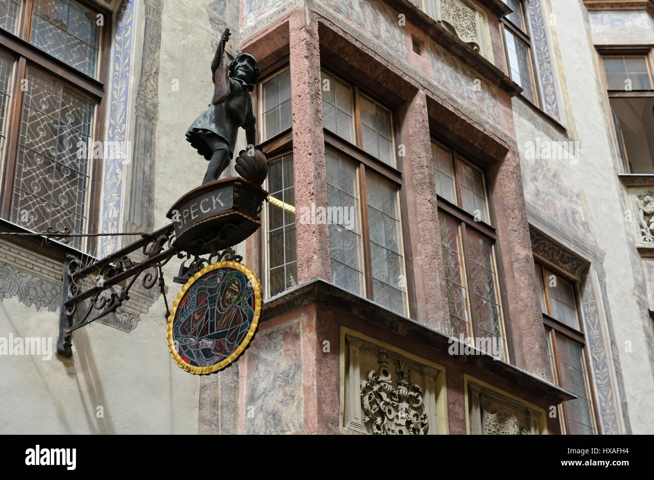 A hanging commercial sign with ' Speck' and a small girl figurine ...