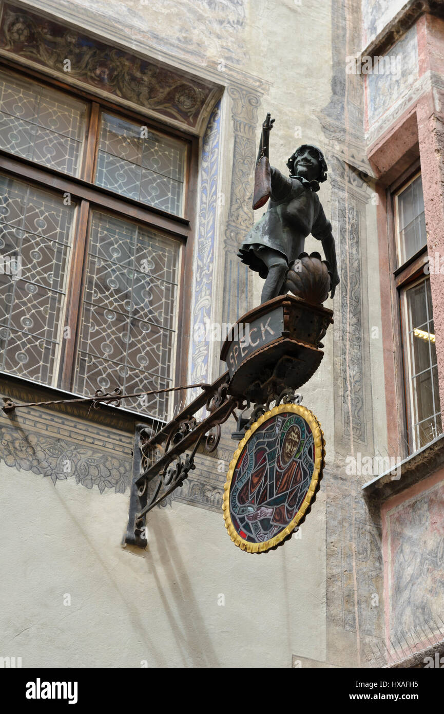 A hanging commercial sign with ' Speck' and a small girl figurine ...