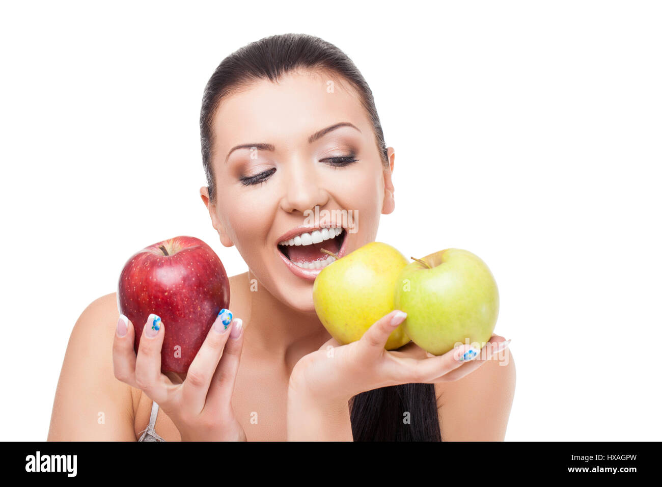 Beautiful happy young woman holding one red and two green apples ...