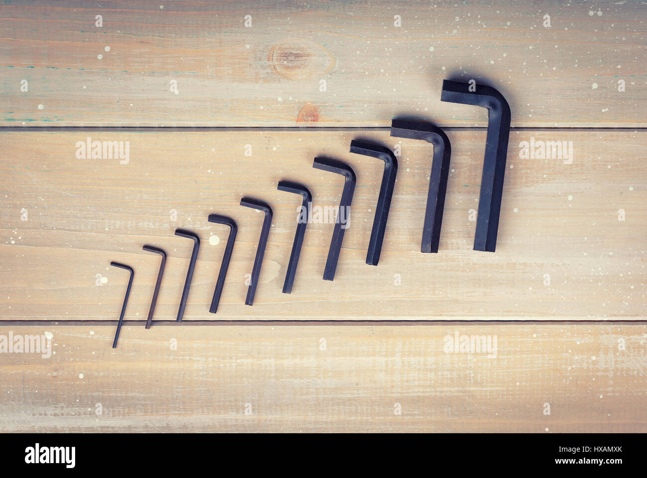 Old hex keys are laid out from the smaller to the larger on a wooden ...