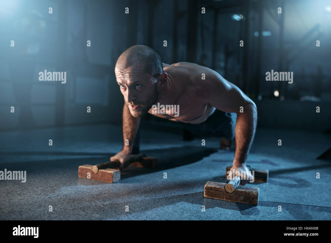 Healthy sportsman makes pushups exercises on training. Strong gymnast ...