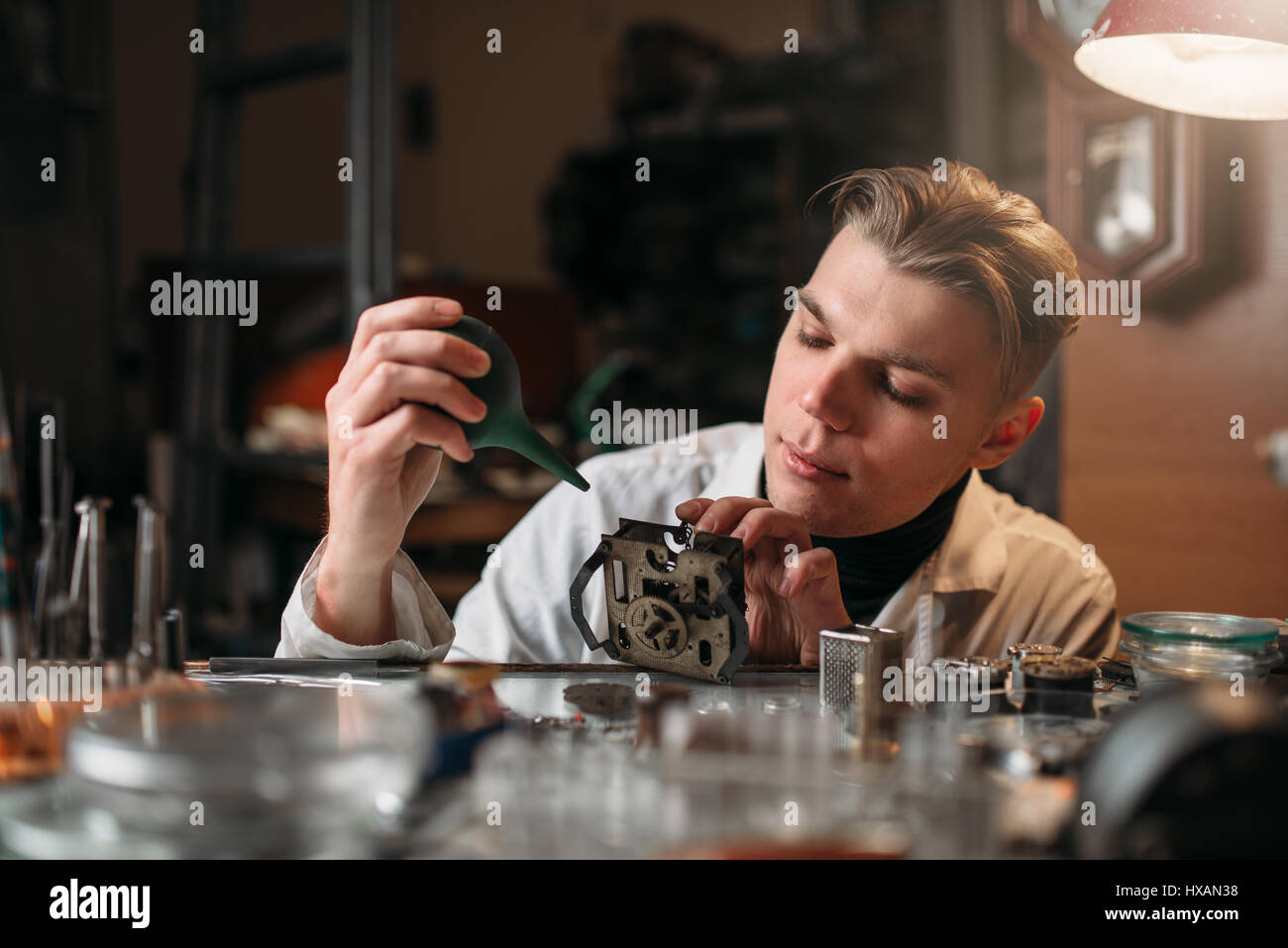 Watchmaker cleans the mechanism of old watches. Clock maker at work ...