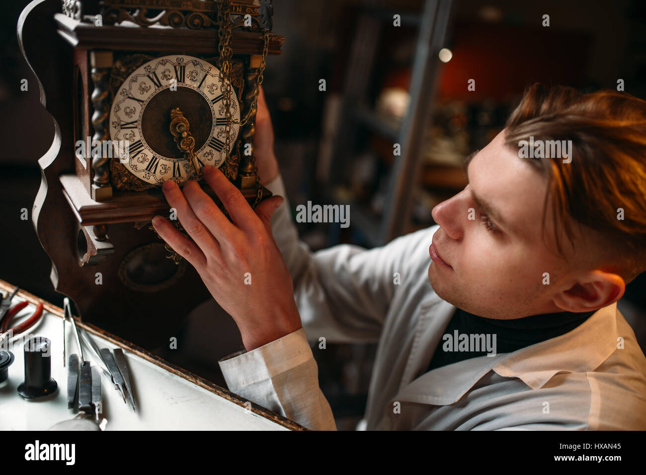 Watchmaker adjusts the mechanism of old watches in the workshop. Clock ...