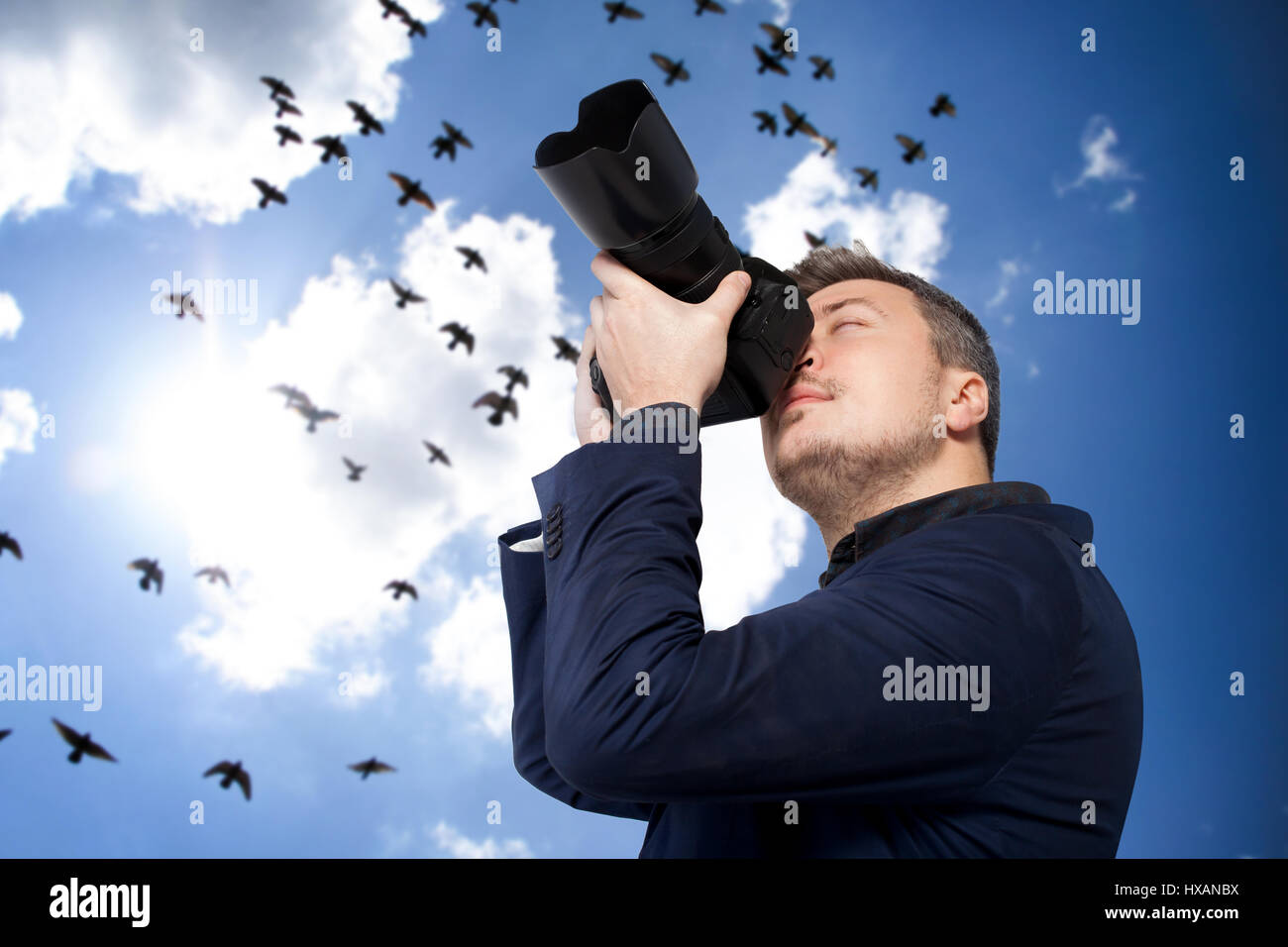 Portrait of male photographer with camera taking a picture, flock of ...