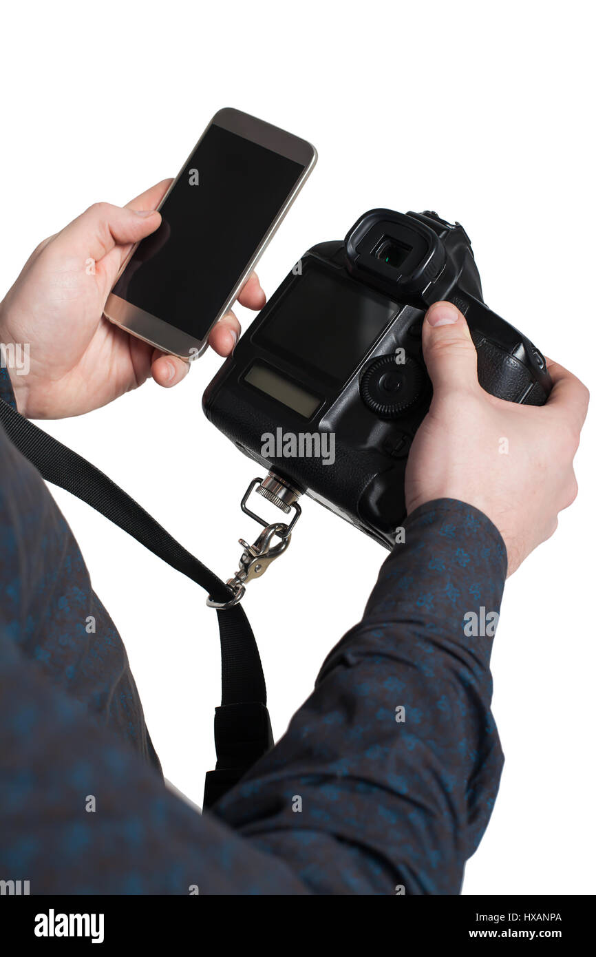 Male hands holding professional digital camera and mobile phone, white ...