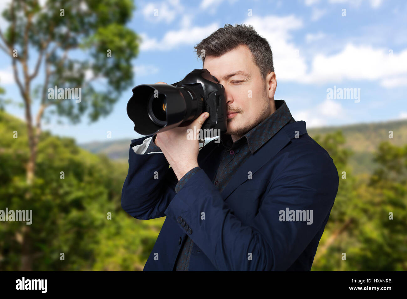 Professional photographer with digital photo camera takes the picture ...