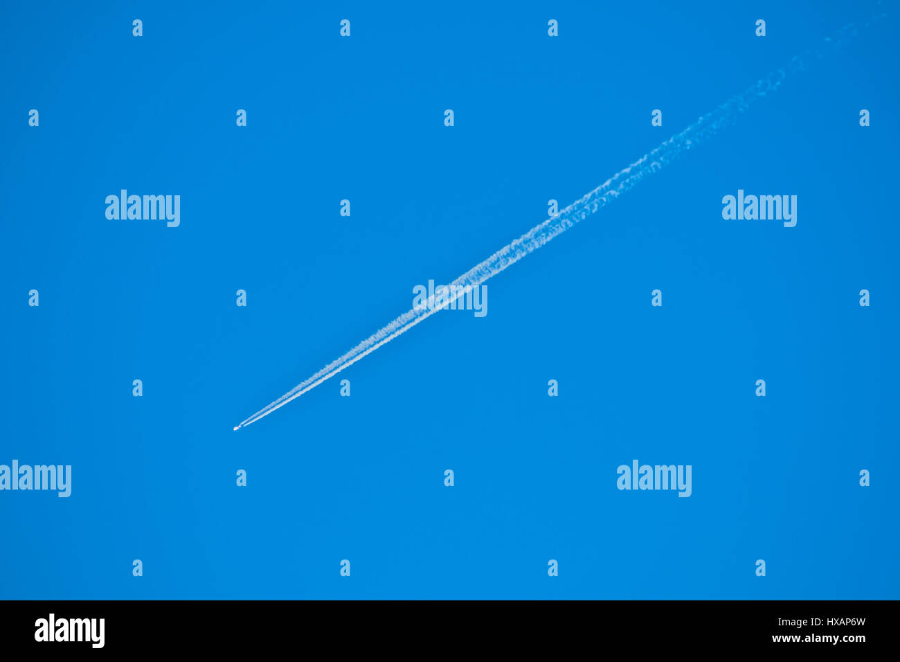 Jet trails in the morning blue sky Stock Photo - Alamy
