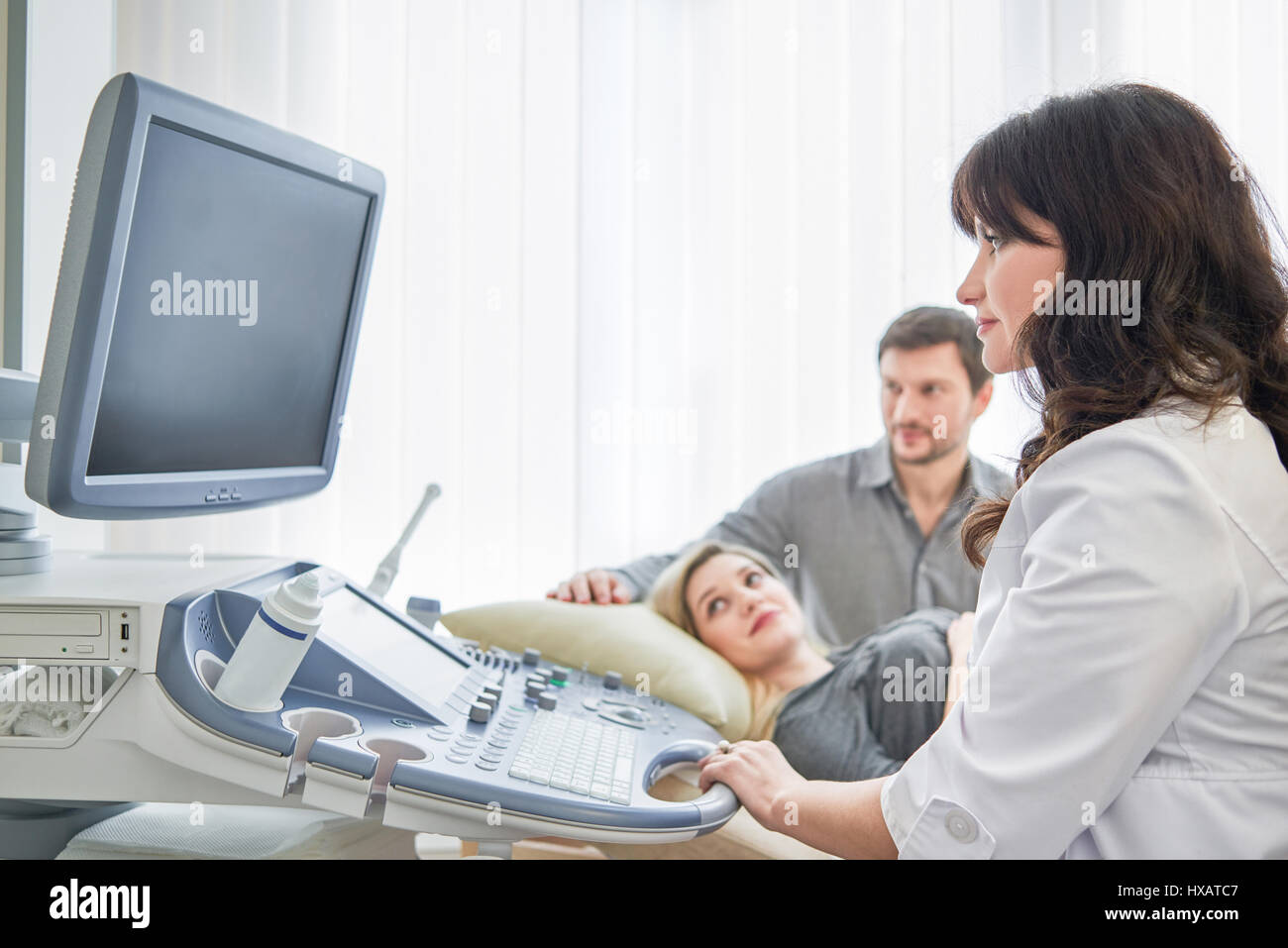 Loving couple attending doctor for pregnancy ultra sound procedu Stock ...