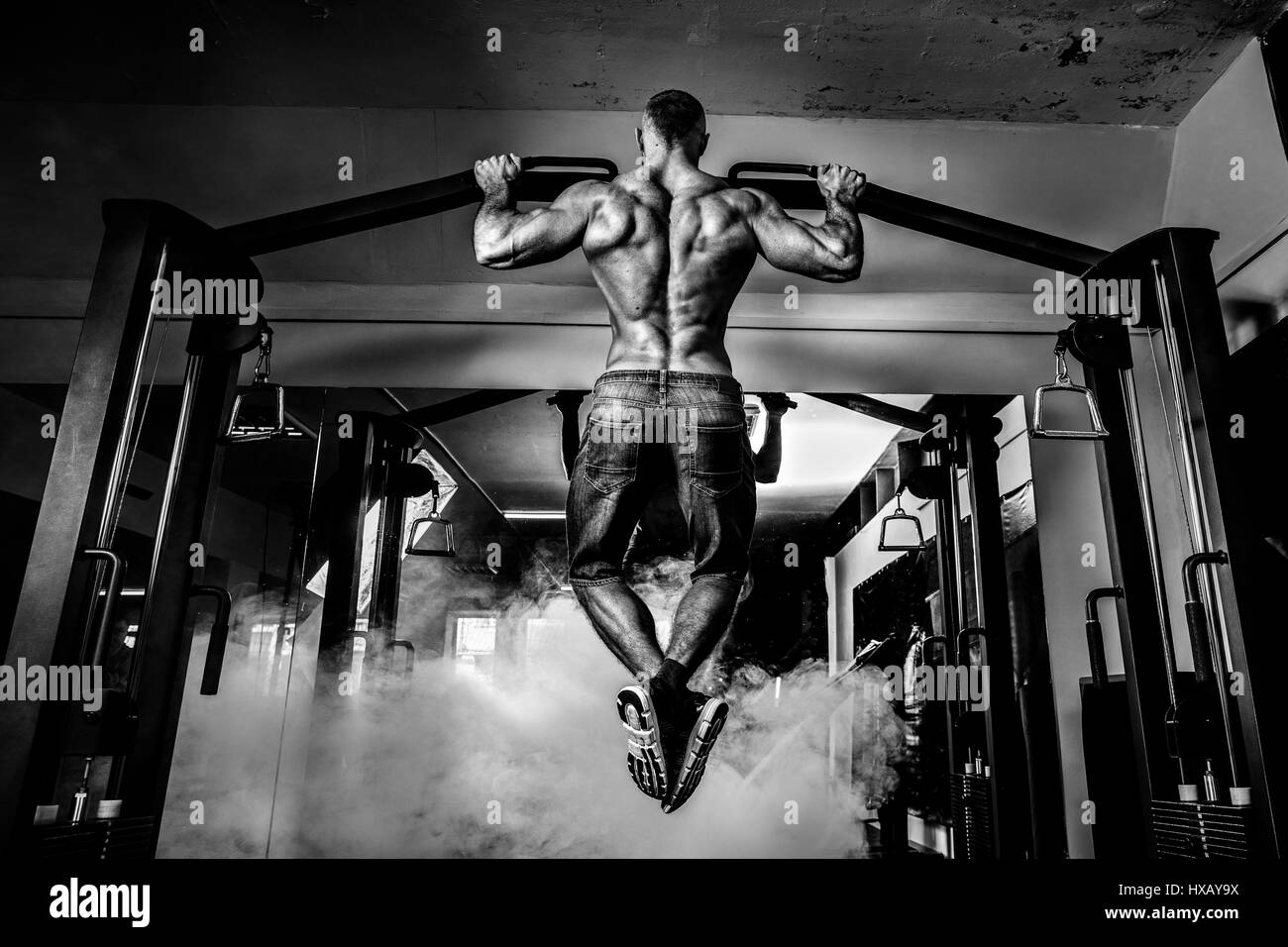 Young athlete exercising on bars in gym Stock Photo - Alamy