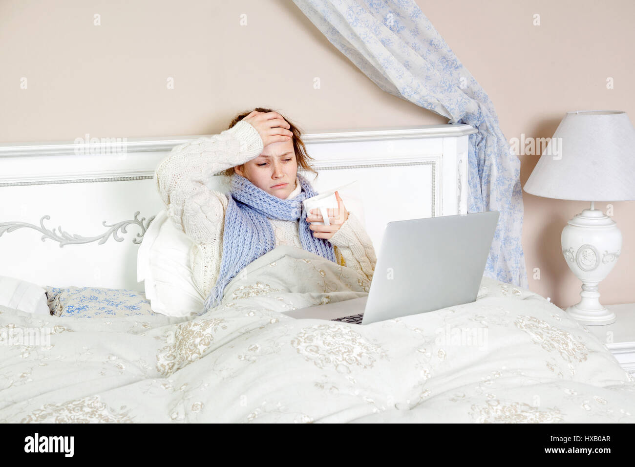 Sick woman feeling bad, resting and working with her laptop and ...