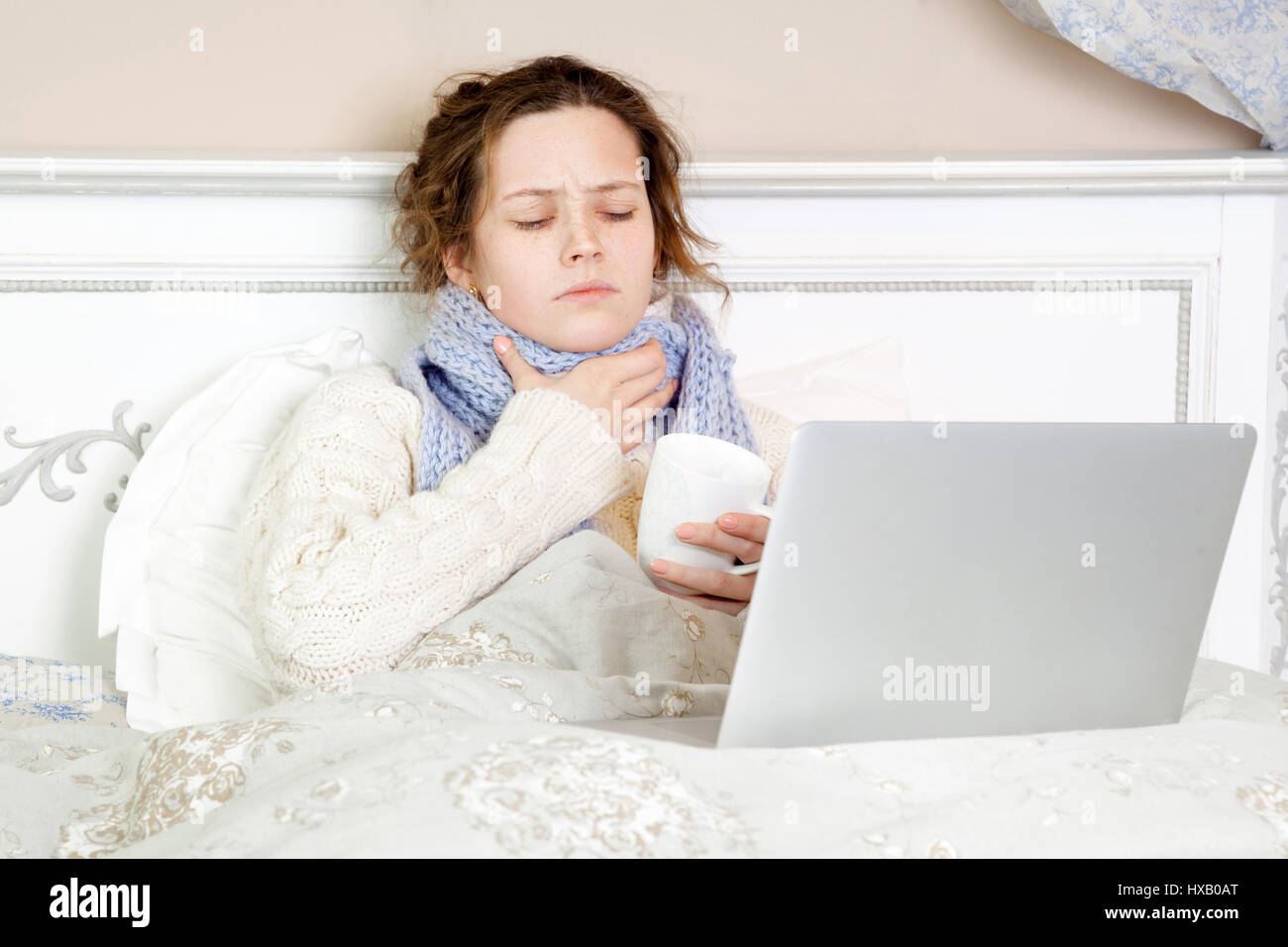 Sick woman feeling bad, resting and working with her laptop and ...