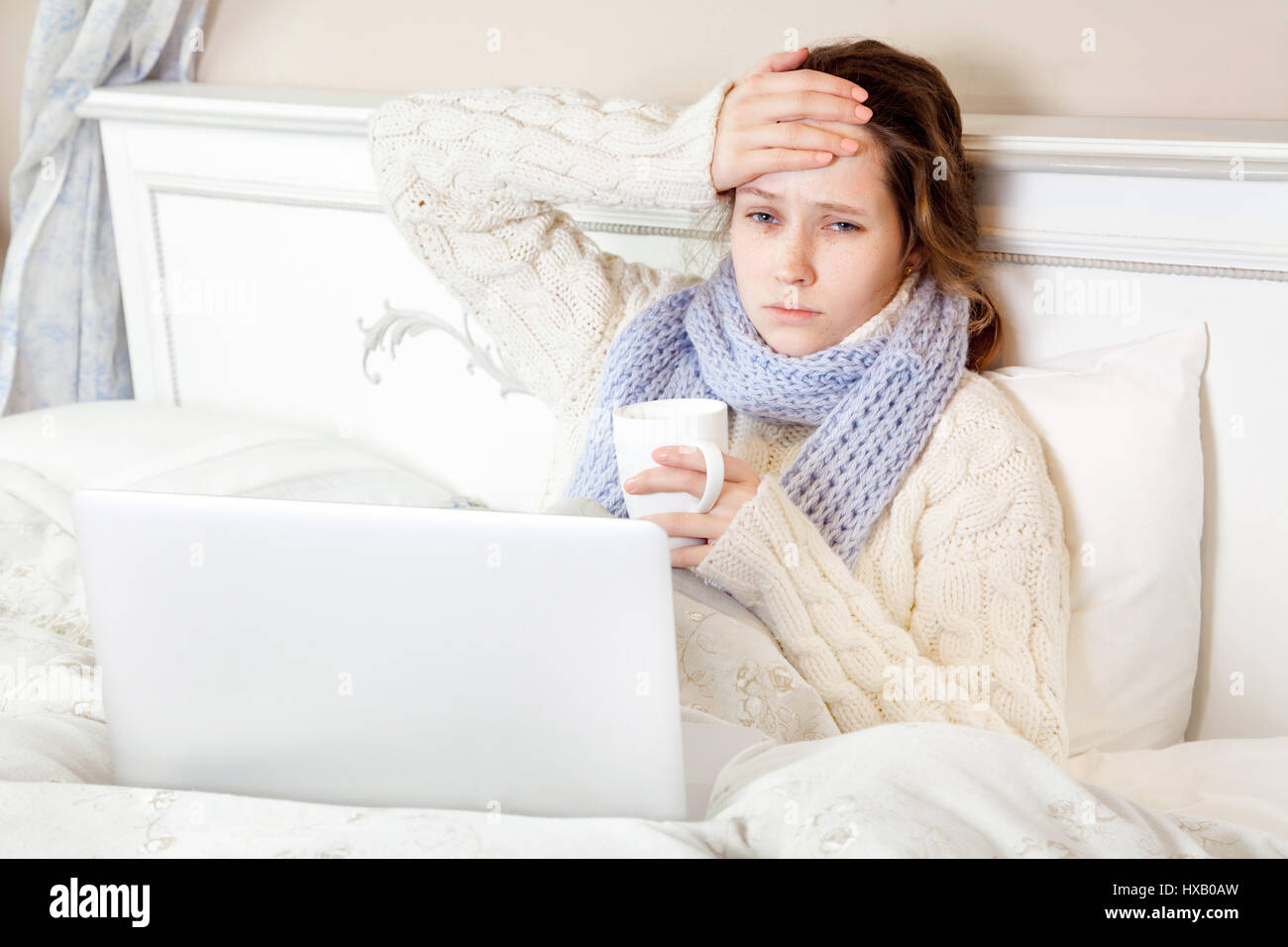 Sick woman feeling bad, resting and working with her laptop and ...