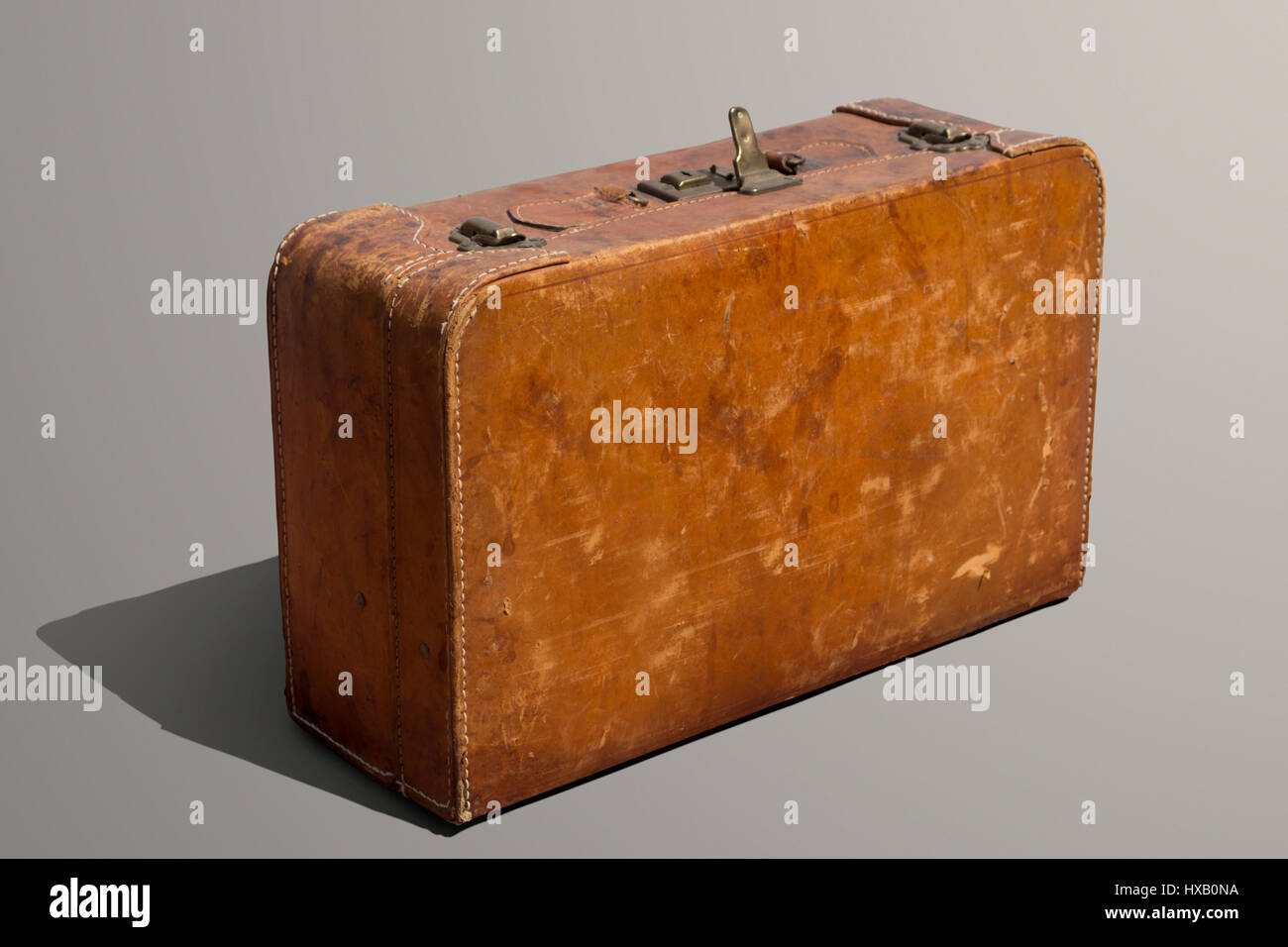 Dusty and scratched old leather standing suitcase Stock Photo - Alamy