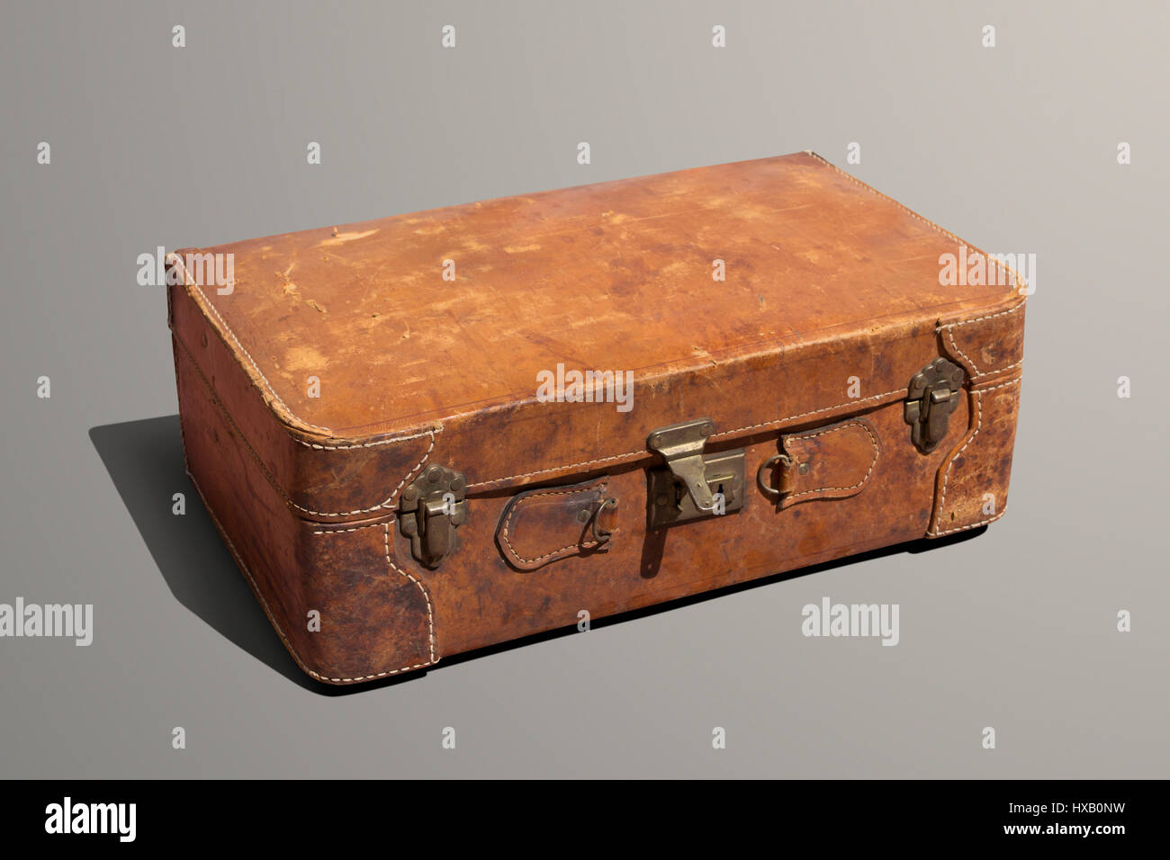 Dusty and scratched old leather suitcase laying down Stock Photo - Alamy