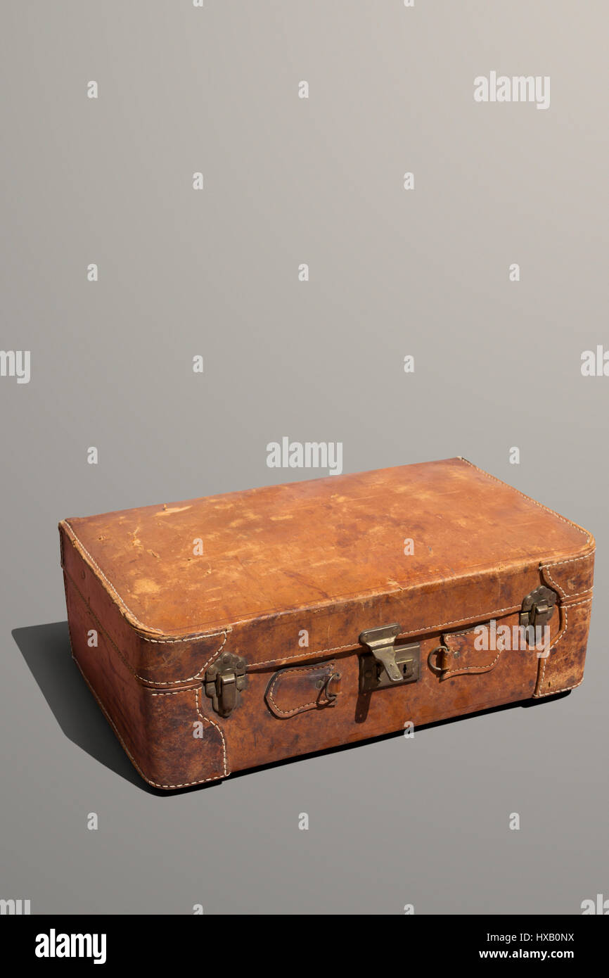 Dusty and scratched old leather suitcase laying down Stock Photo - Alamy