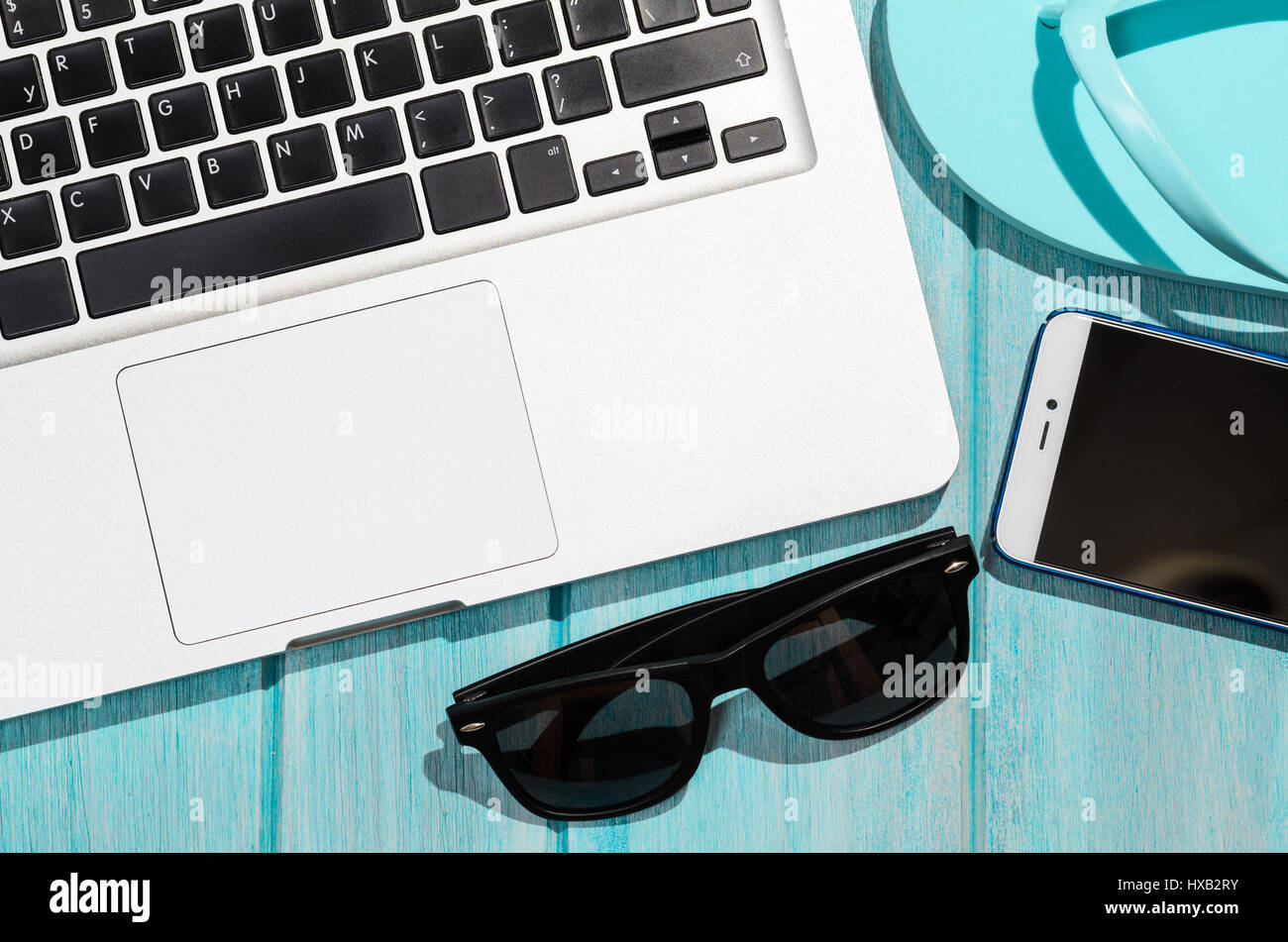 Work on the go. Modern laptop computer with smartphone and sunglasses ...