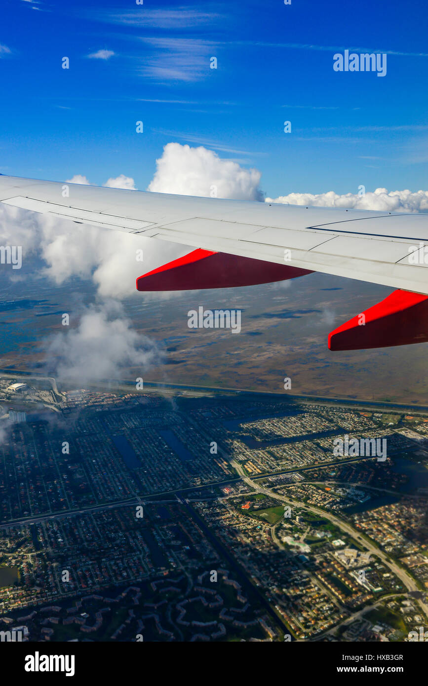 Aerial view from airplane window of plane's wing in foreground and ...