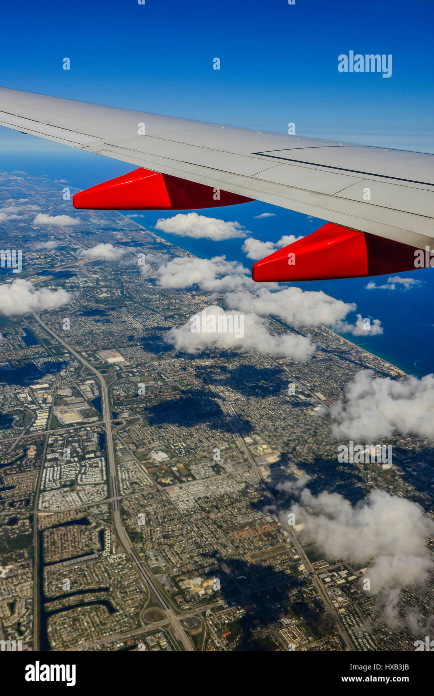 Aerial view from airplane window of plane's wing in foreground and ...