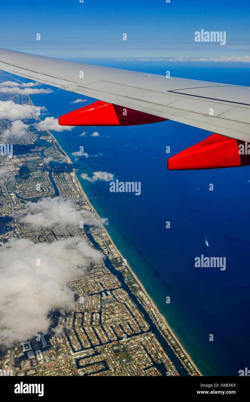 Aerial view from airplane window of plane's wing in foreground and ...