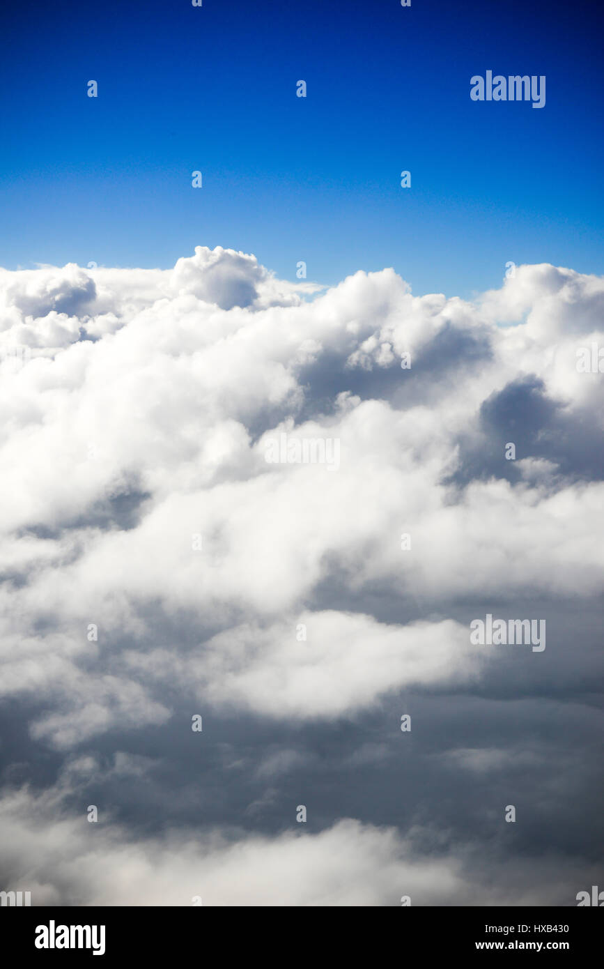 A dramatic aerial view from above the clouds and blue sky horizon from ...