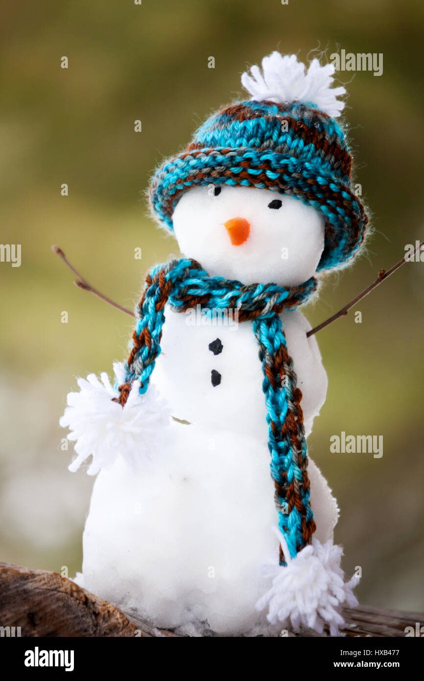 Snowman with handmade hat and scarf Stock Photo - Alamy