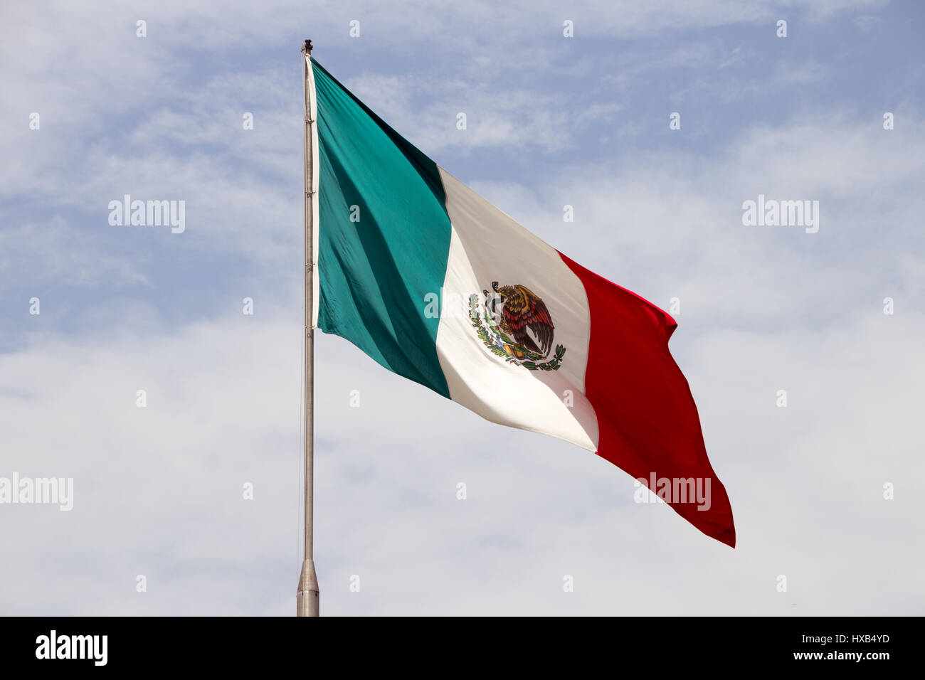Photograph of a mexican flag and blue cloudy sky Stock Photo - Alamy