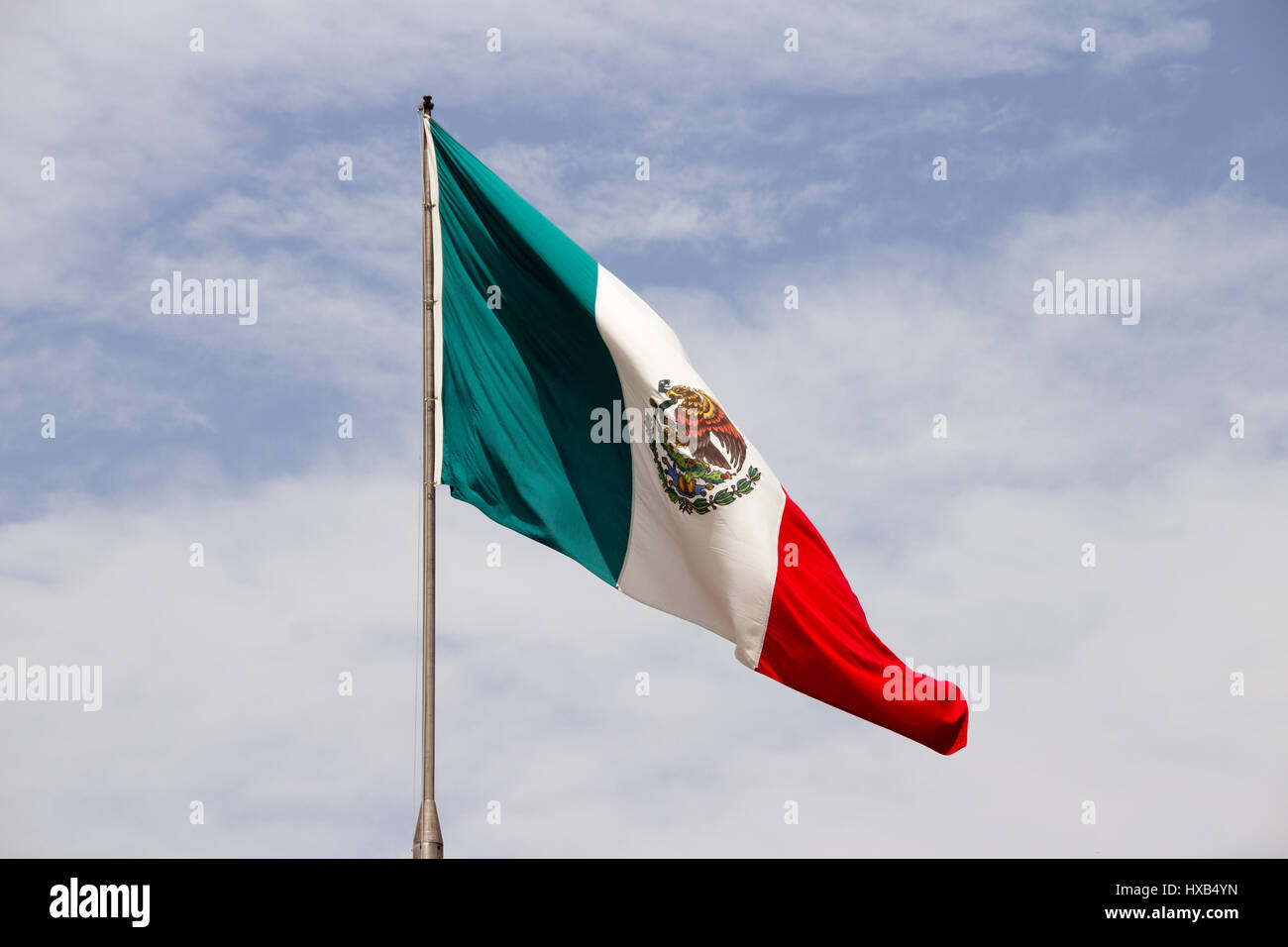 Photograph of a mexican flag and blue cloudy sky Stock Photo - Alamy