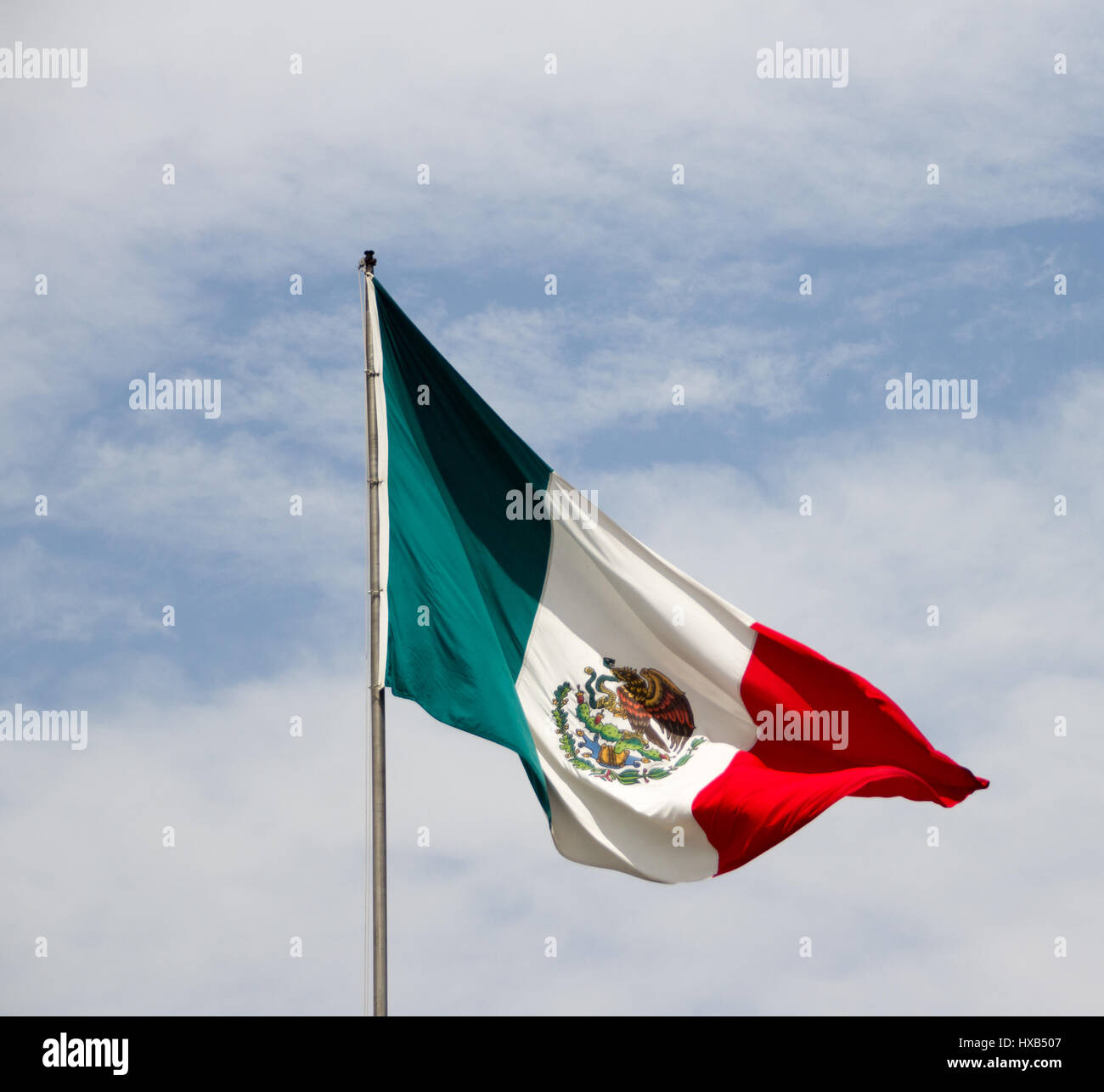 Photograph of a mexican flag and blue cloudy sky Stock Photo - Alamy