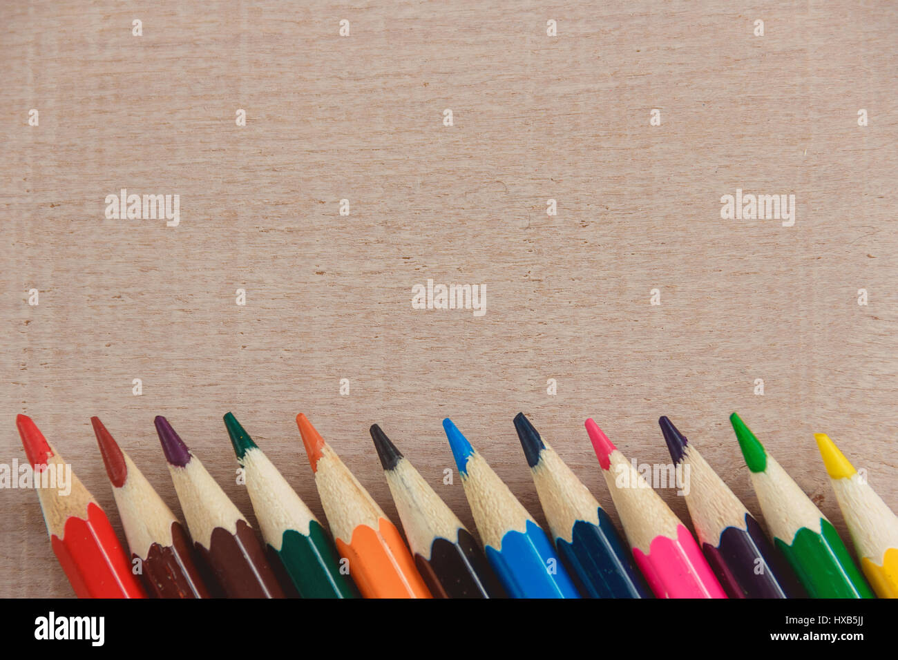 Colour pencils on wooden texture background Stock Photo - Alamy