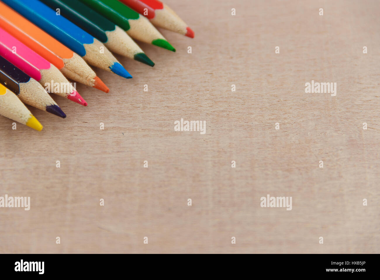 Colour pencils on wooden texture background Stock Photo - Alamy