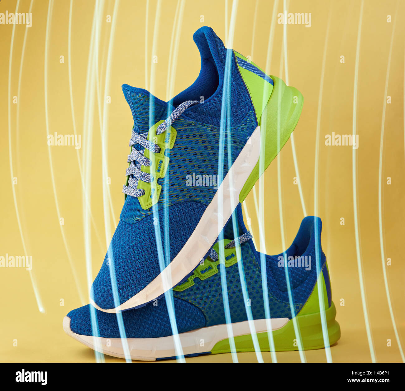 Colorful pair of running shoes illuminated with light on yellow ...