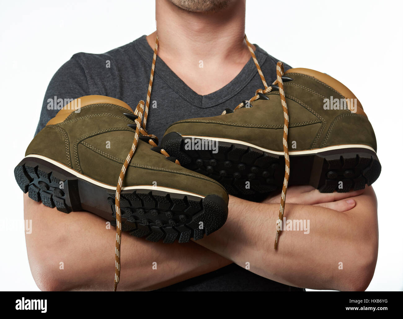 Man with hiking shoes hang on neck. Pair of outdoor shoes hanging on ...