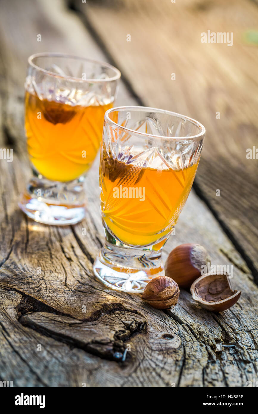 Sweet liqueur with hazelnuts and alcohol on old wooden table Stock ...
